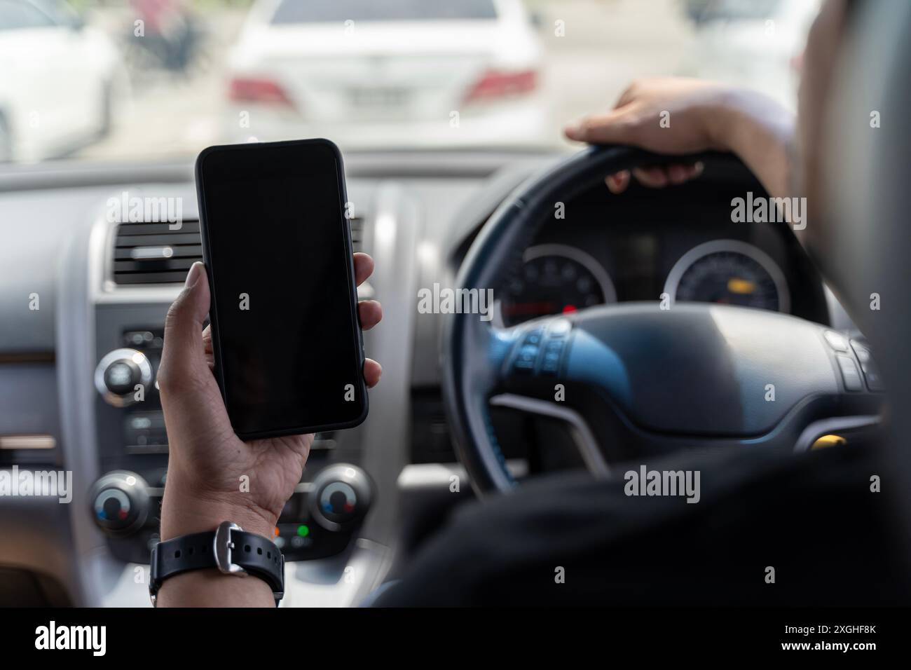 Mock up of man using mobile smart phone inside a car. Driver hand ...