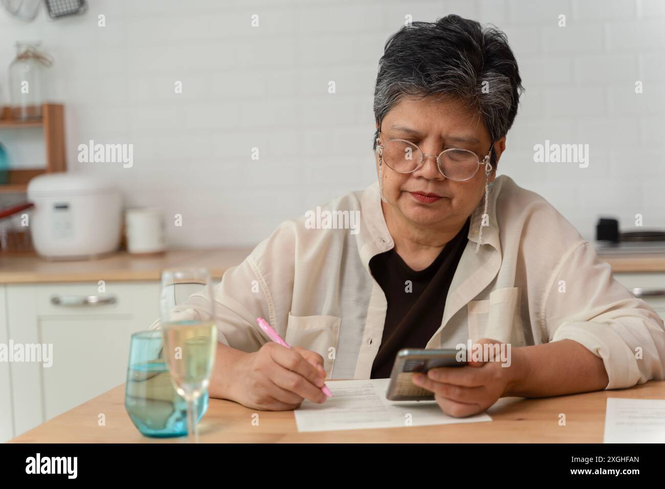 Senior old woman writing down letters on a piece of paper, record ...