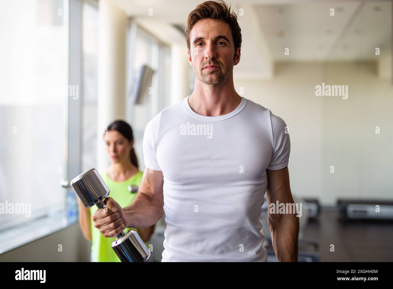 Group of young fit people exercising together during their workout in a ...