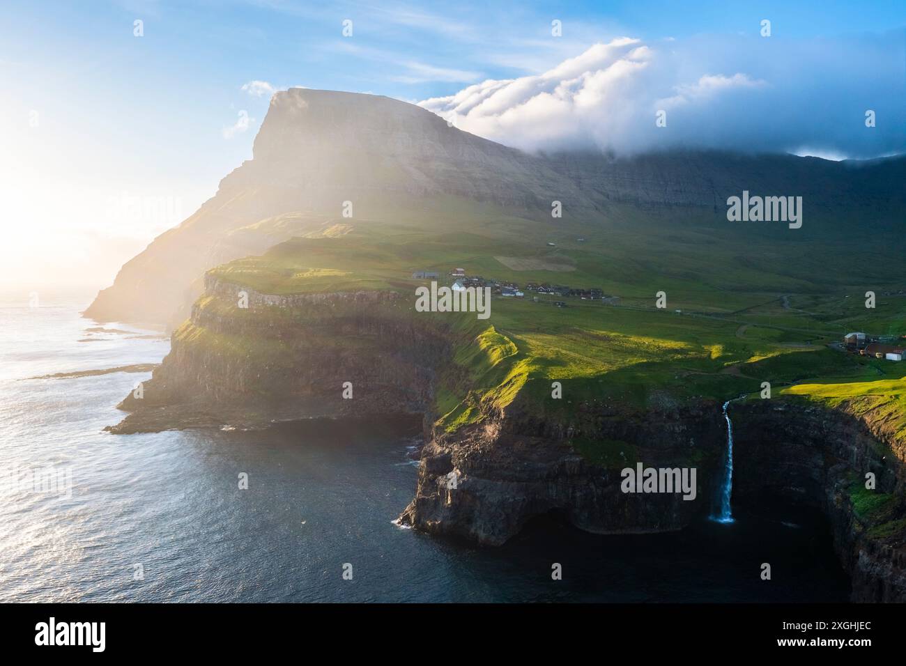 Aerial view of the Mulafossur waterfall with the small village of ...