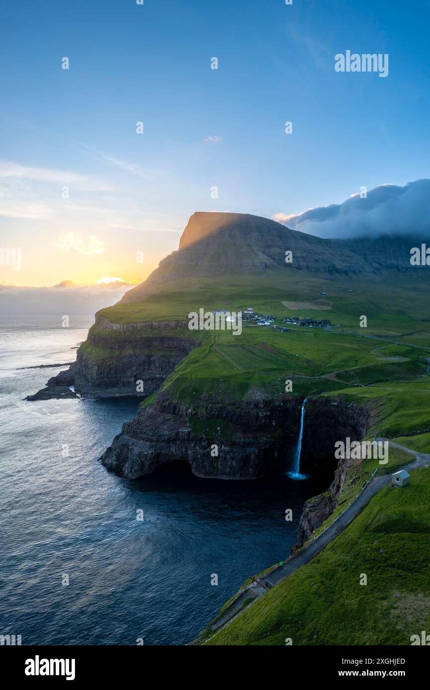 Aerial view of the Mulafossur waterfall with the small village of ...