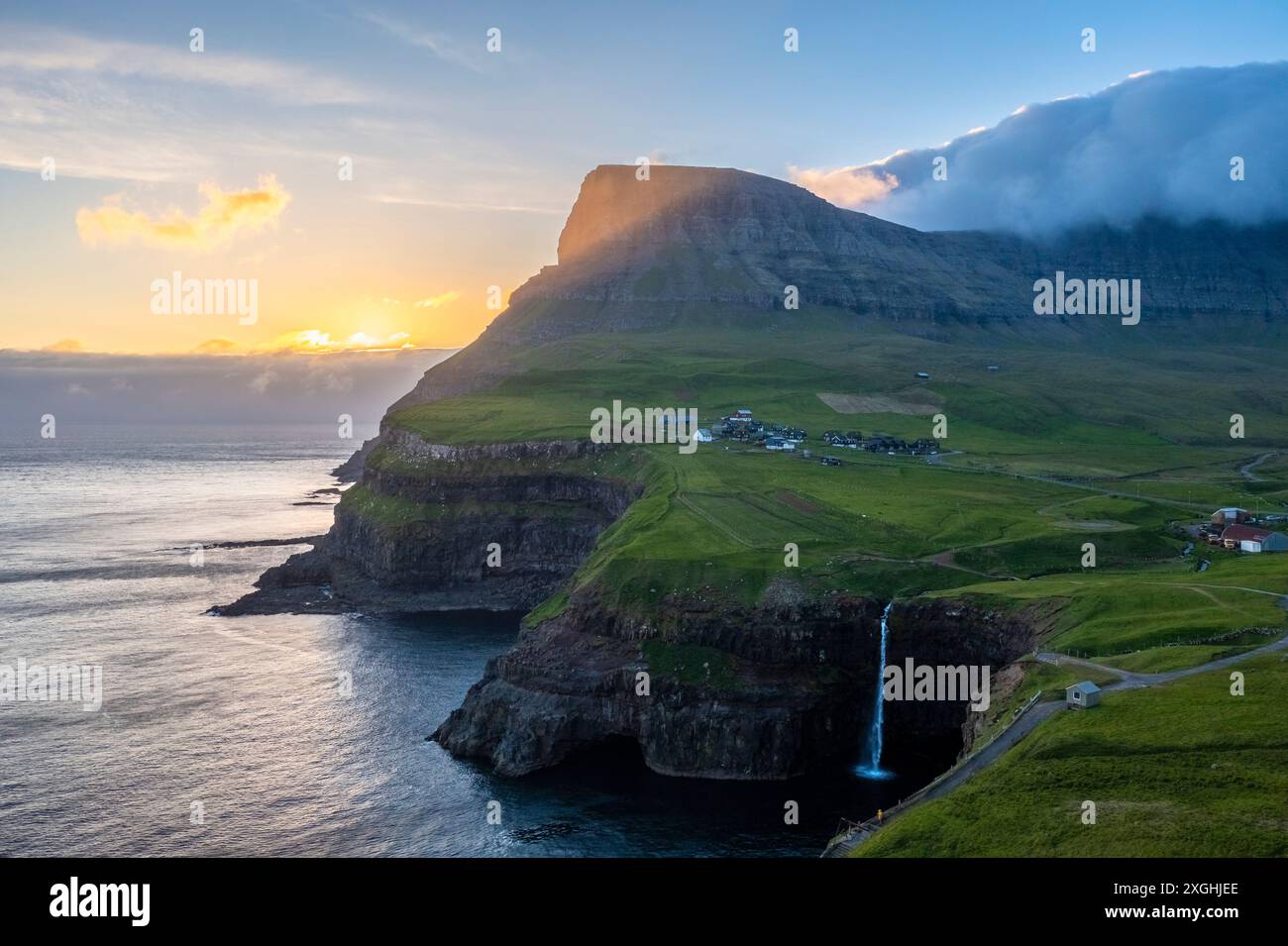 Aerial view of the Mulafossur waterfall with the small village of ...