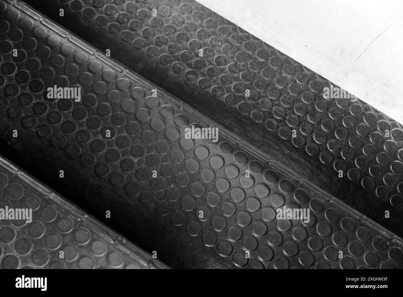 Black rubber mat with a non-slip pattern covers an industrial stairway ...