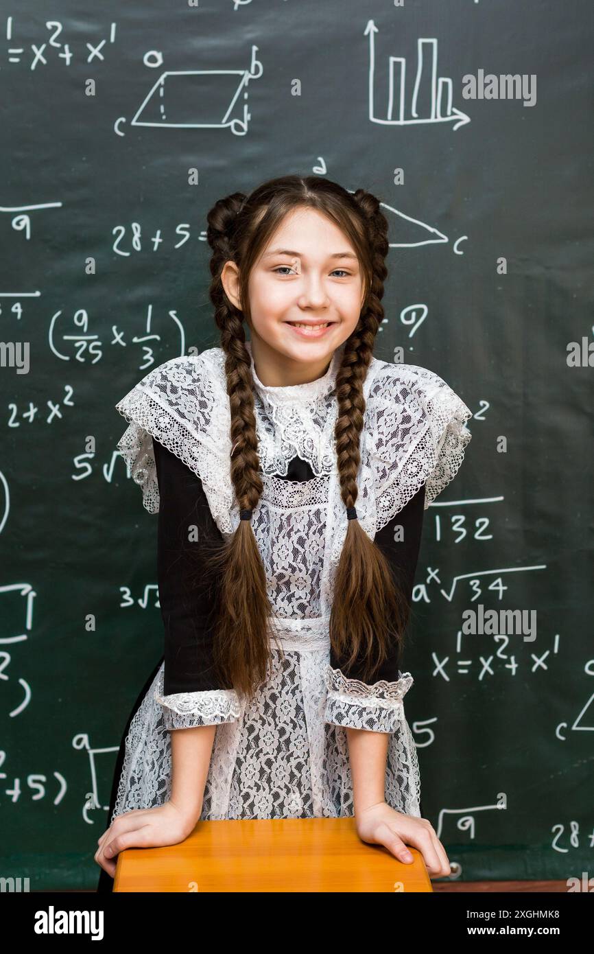 Schoolgirl in school uniform with white apron, festive clothes for ...
