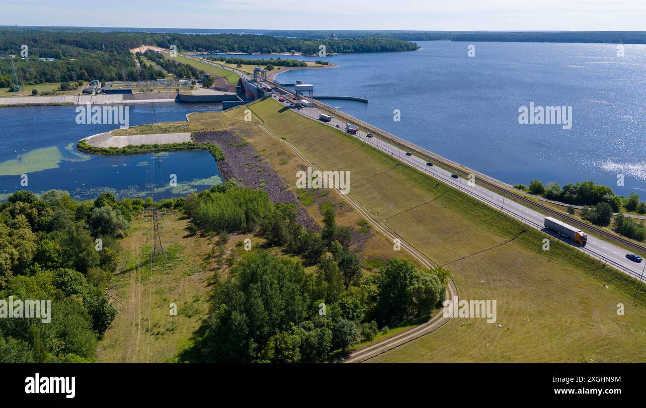 Drone photography of a hydro dam, forest and road with traffic driving ...