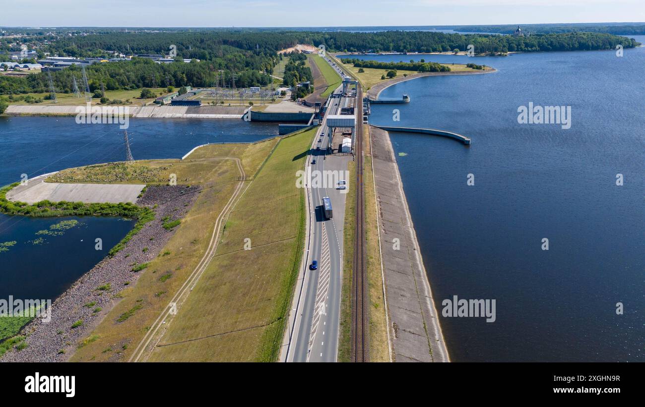 Drone photography of a hydro dam, forest and road with traffic driving ...