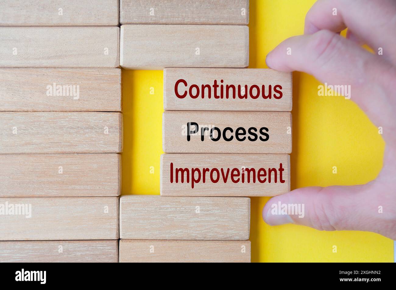 Hand pulling wooden blocks with continuous process improvement text ...