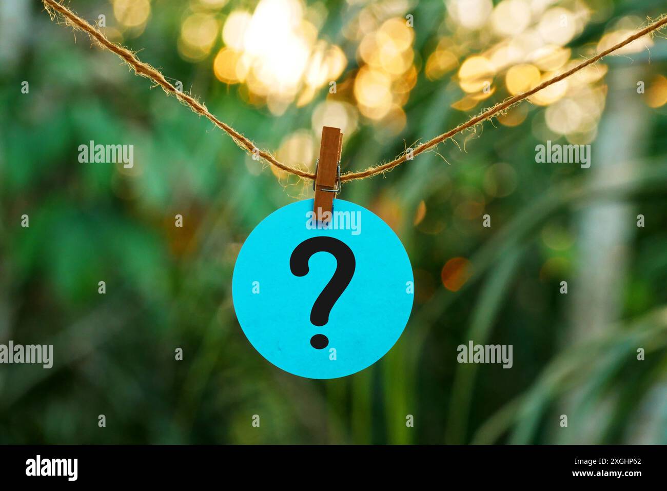 a question mark in blue paper stuck hanging from a string Stock Photo ...