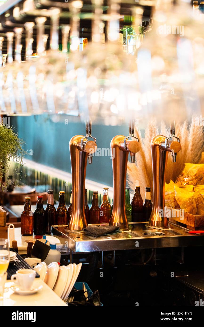 Bar with three beer pours and glasses hanging overhead. Vertical Stock ...