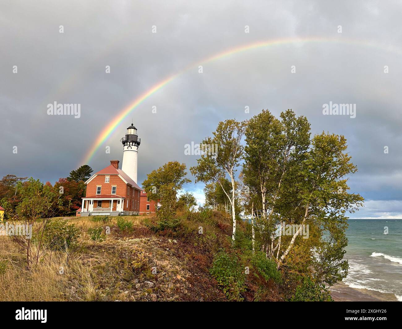 A rainbow in a cloudy sky over Au Sable Lighthouse on the shore of Lake ...
