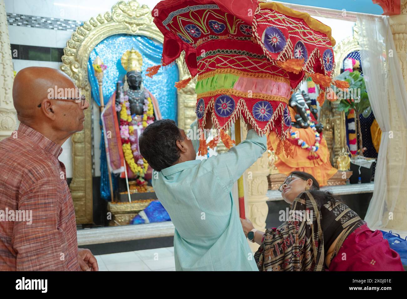 At the Wilton Hindu temple, 3 devotees prepare a colorful ornament to ...