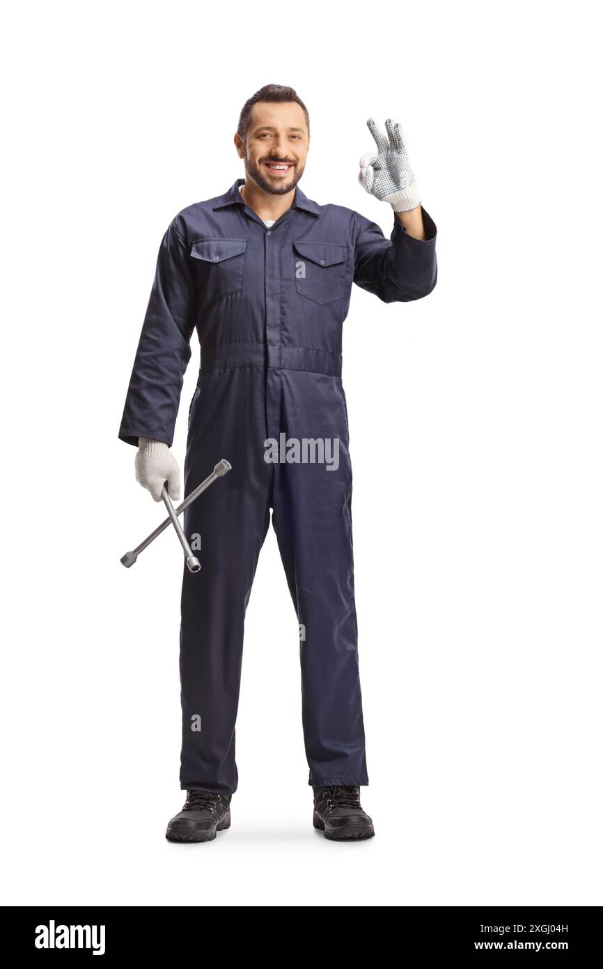 Car mechanic holding a wrench and gesturing ok sign isolated on white ...