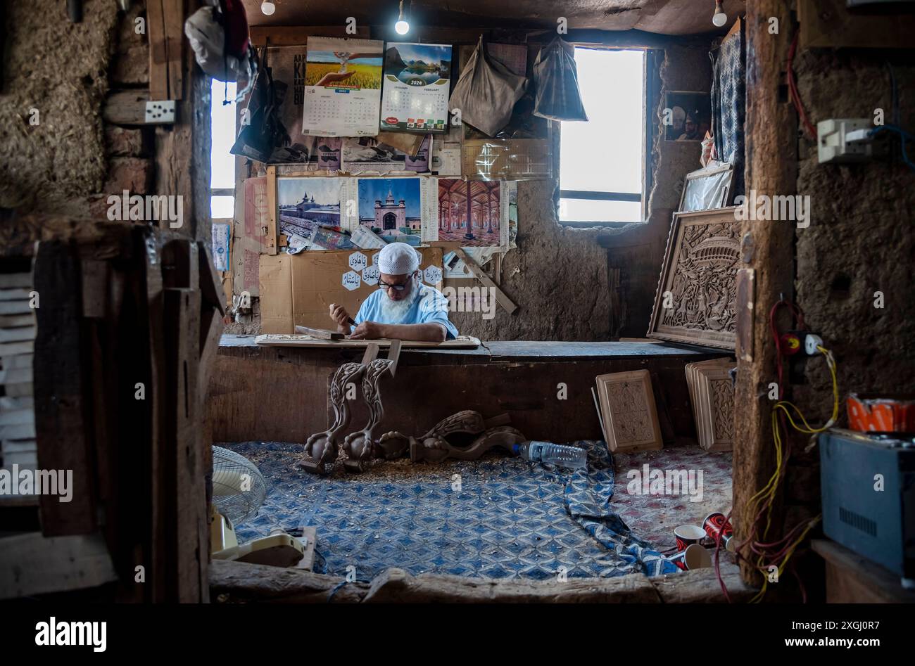 A master artisan is seen crafting designs on a wooden piece at his ...