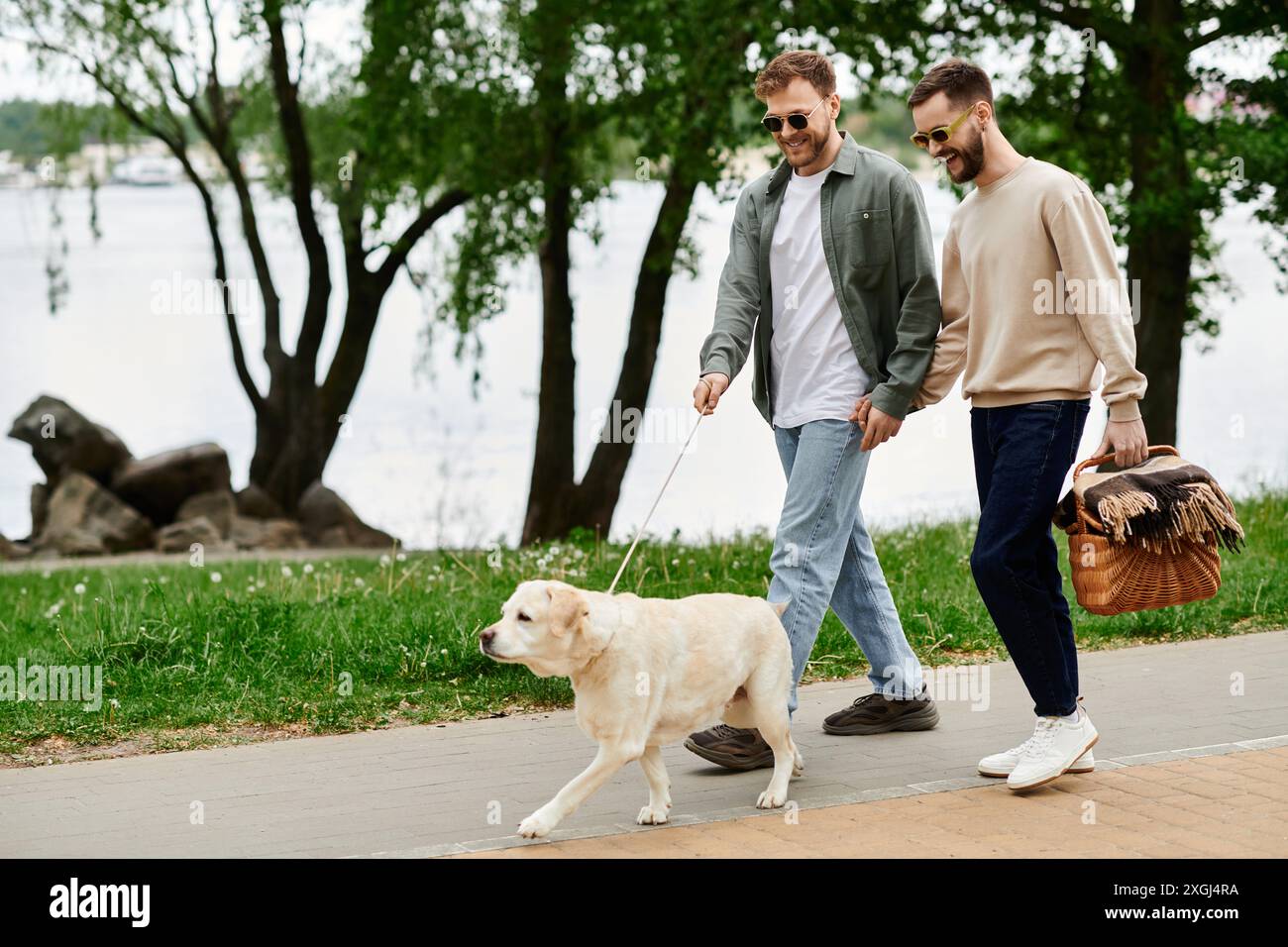 Two bearded gay men walk with their labrador retriever dog through a ...