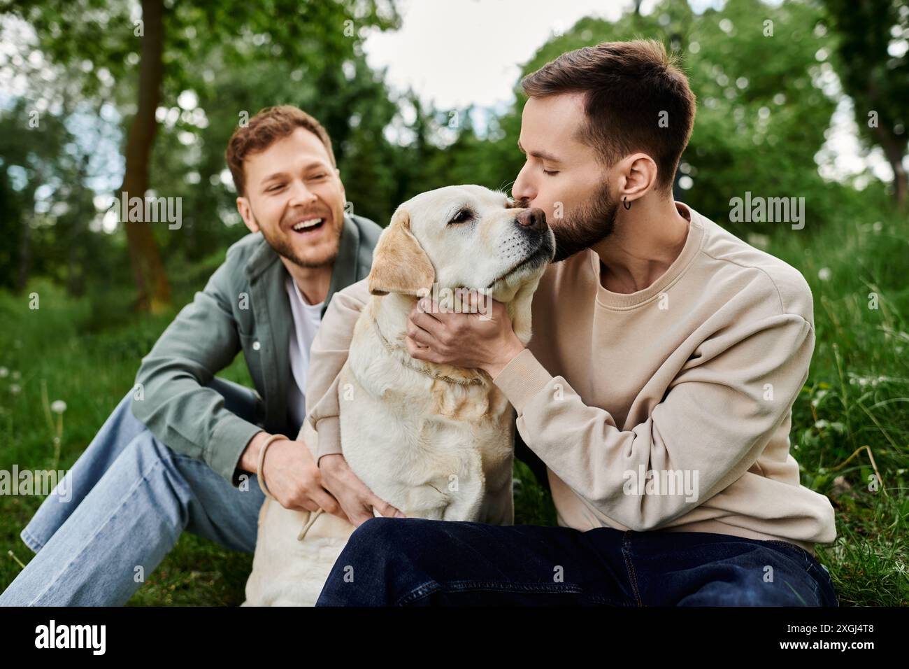 Two bearded men enjoying a day with their Labrador dog in a grassy park ...