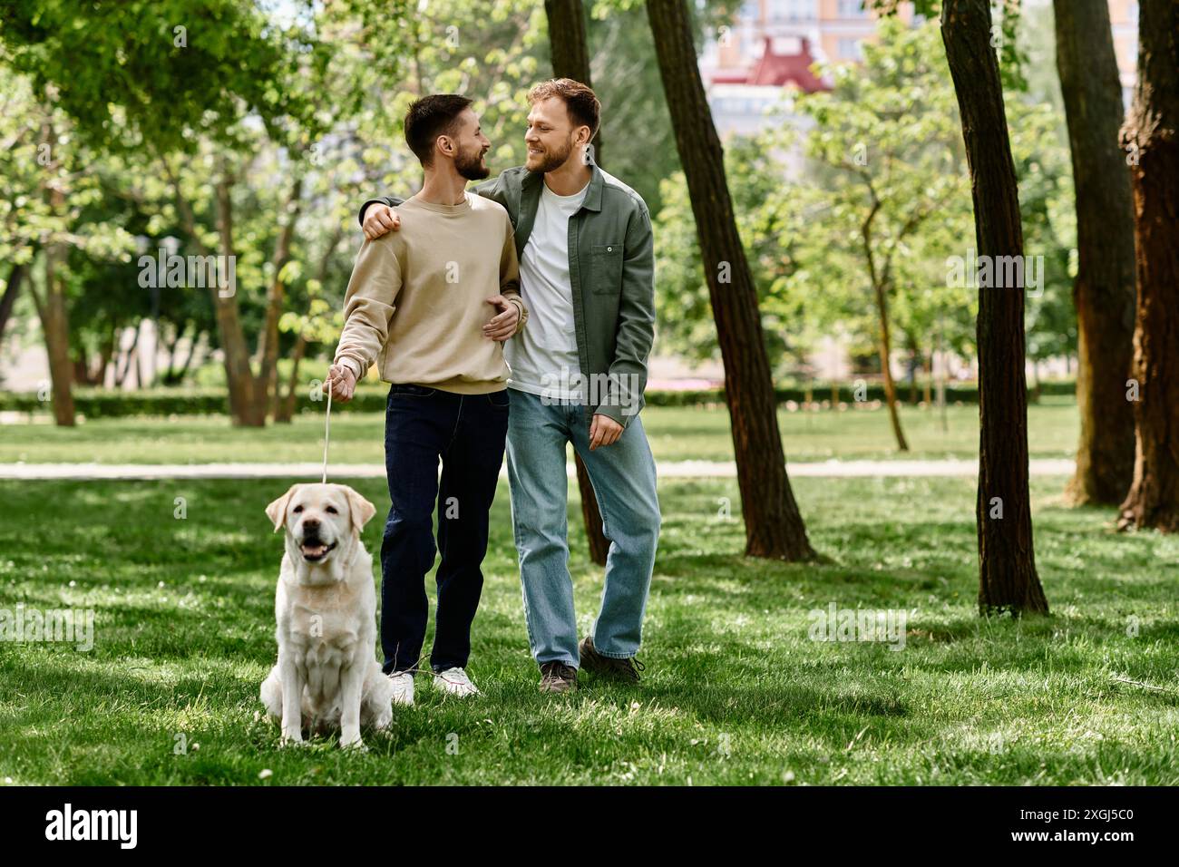 A bearded gay couple walks hand-in-hand through a green park with their ...