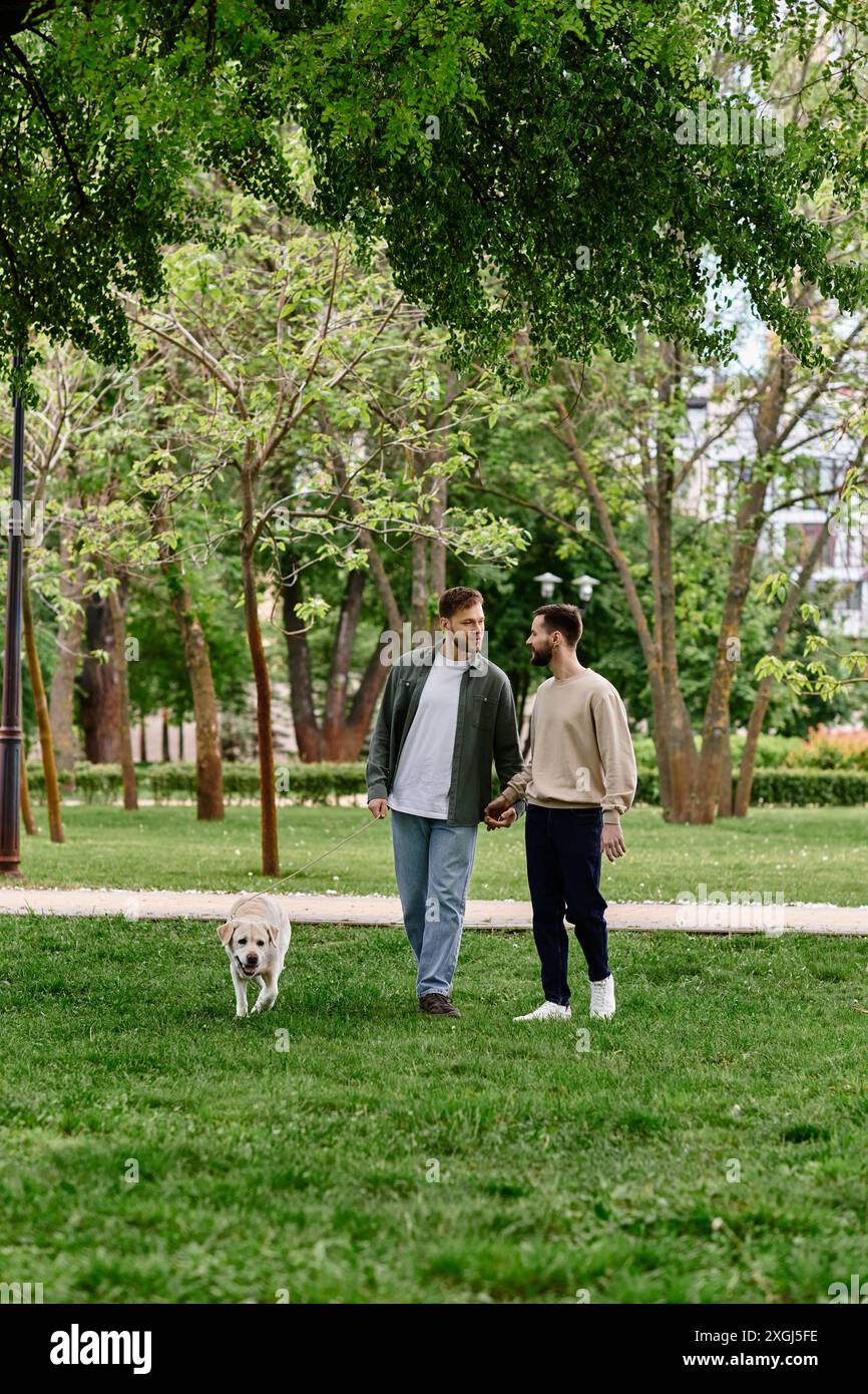 A bearded gay couple walks hand-in-hand through a verdant park with ...