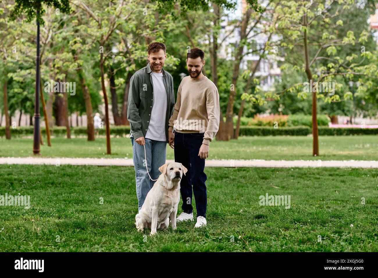 Two bearded men, a gay couple, walk with their labrador dog through a ...