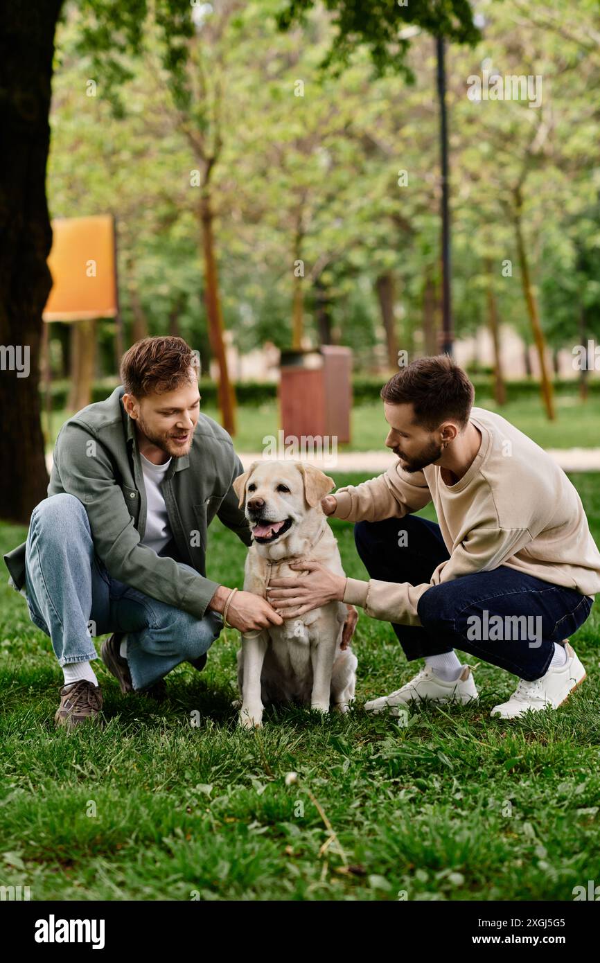 Two bearded men in casual clothing are squatting on green grass and ...
