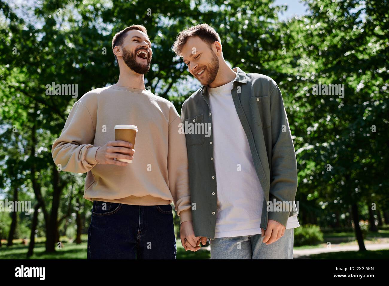 A Bearded Gay Couple Walks Through A Green Park Laughing And Enjoying Each Others Company Stock