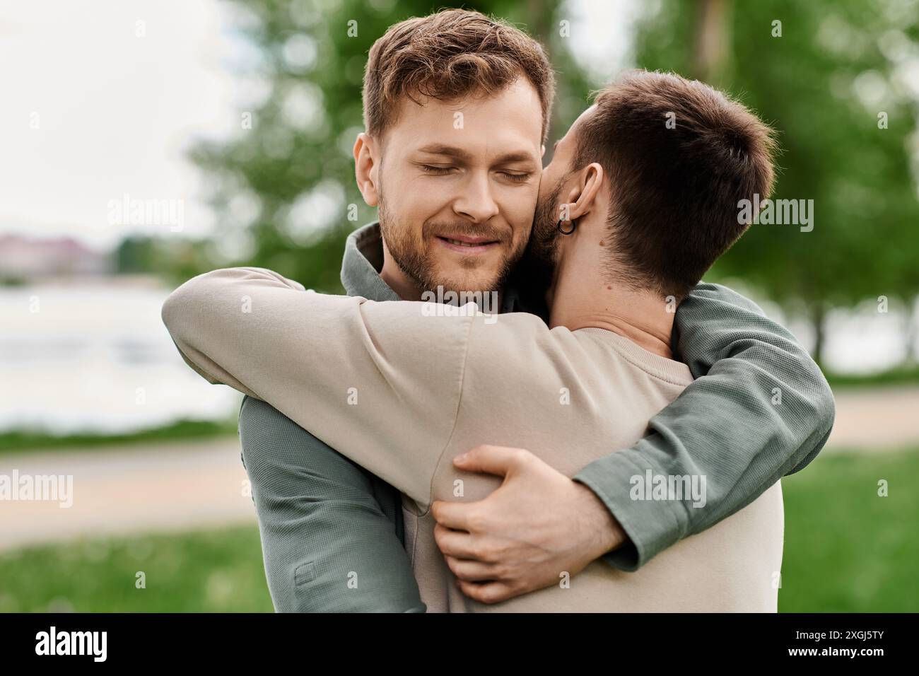 Two bearded men embrace in a green park Stock Photo - Alamy