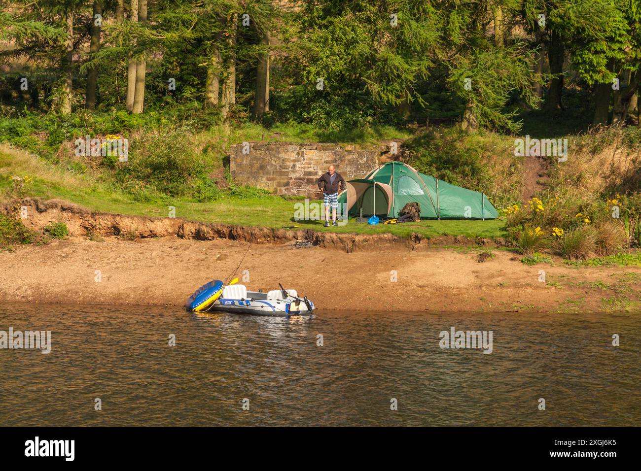 A middle aged man camping on the banks of Cod Beck Reservoir ,North ...