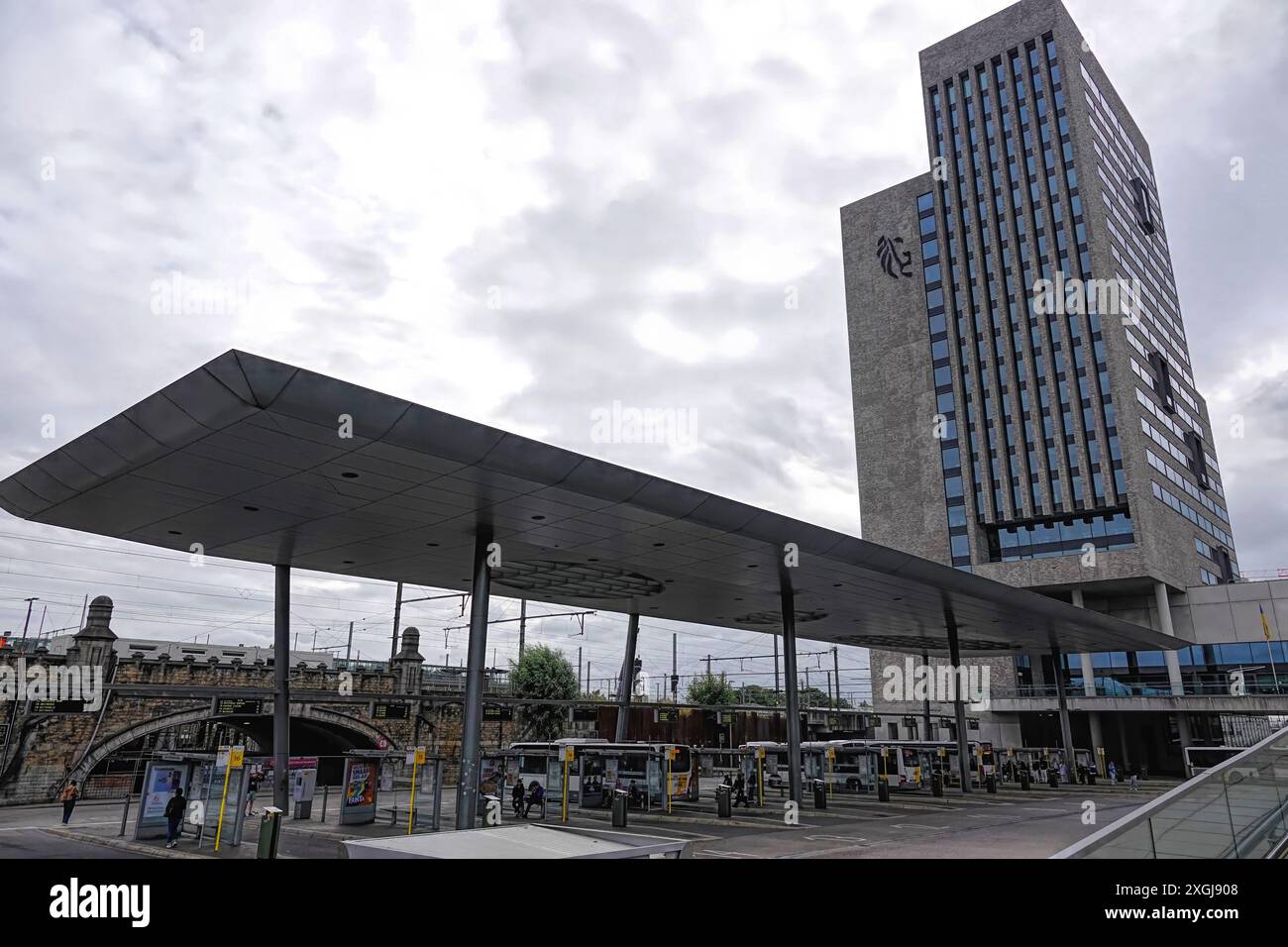 Modern bus station with a high-rise office building and cloudy sky in ...
