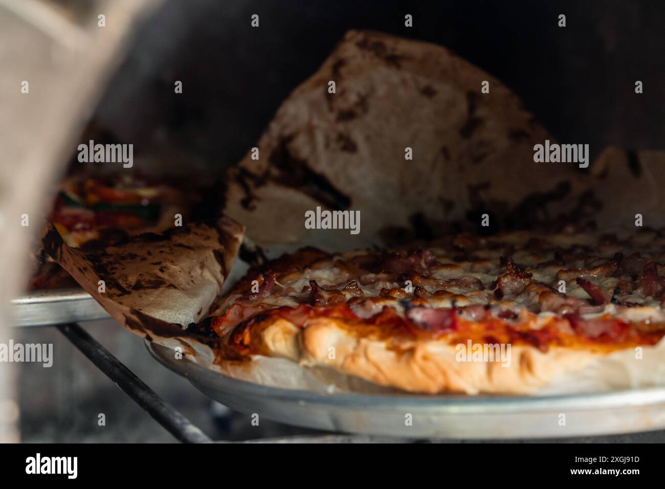 closeup the process of two pizzas baking inside a traditional stone ...