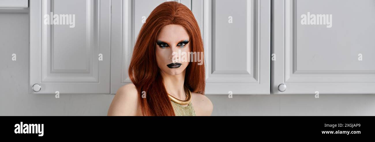 A drag queen poses in a kitchen with white cabinets, wearing a ...