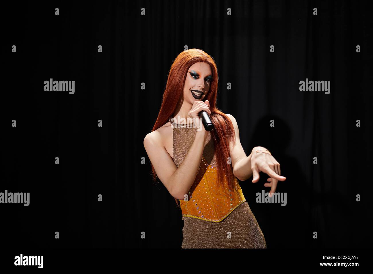 A drag performer sings into a microphone on stage, showcasing their ...