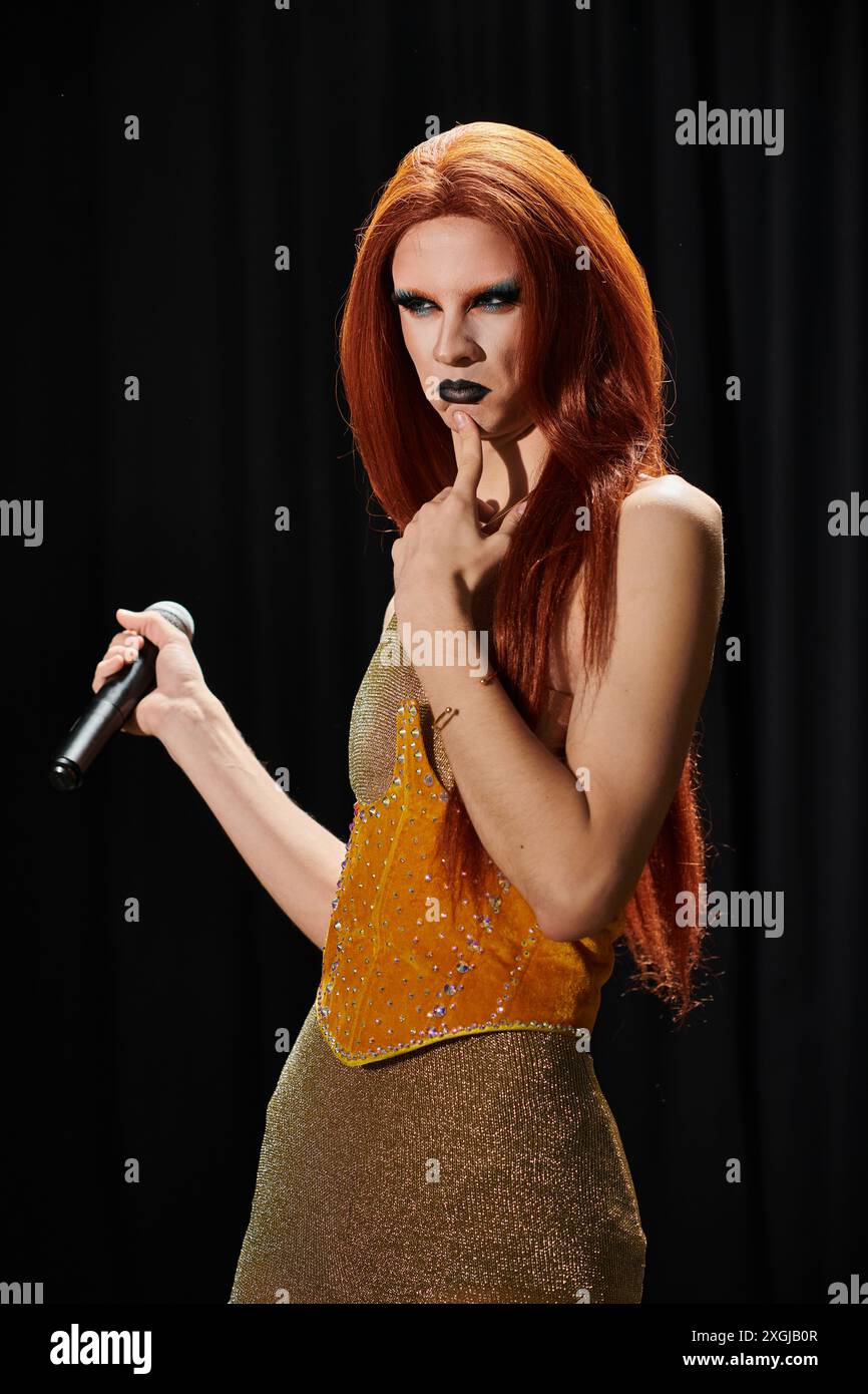 A drag queen in a sparkling gold outfit poses with a microphone ...
