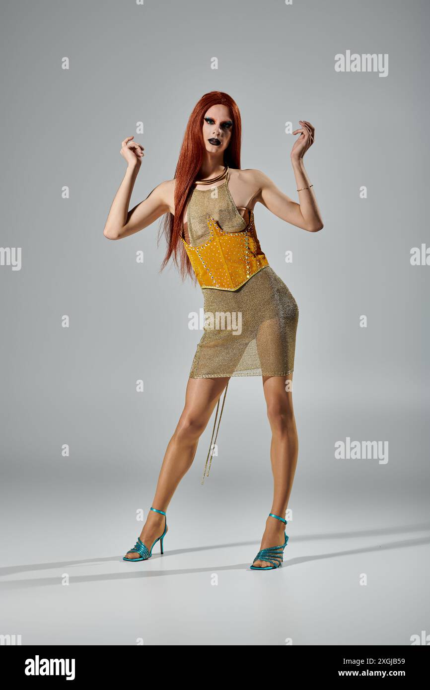 A drag performer poses in a gold, sequin dress and matching turquoise ...