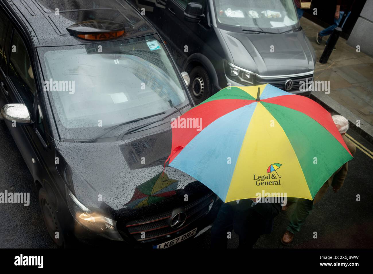 A pedestrian carries a Legal &General insurance group brolly past ...