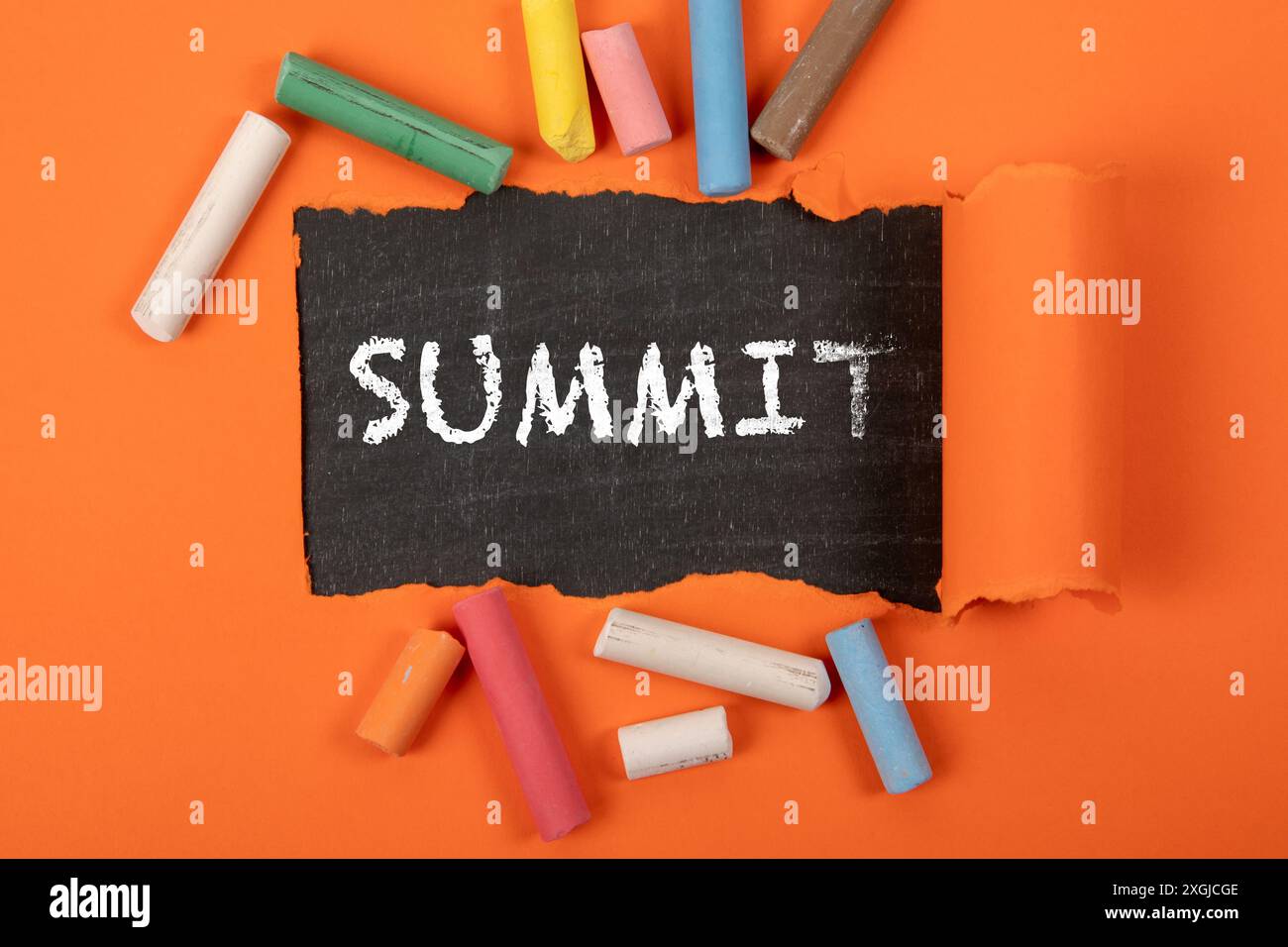 SUMMIT. Word under torn orange paper on a blackboard Stock Photo - Alamy