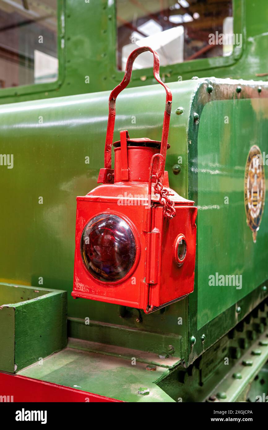 Vintage red lantern mounted on an old green steam locomotive in a ...