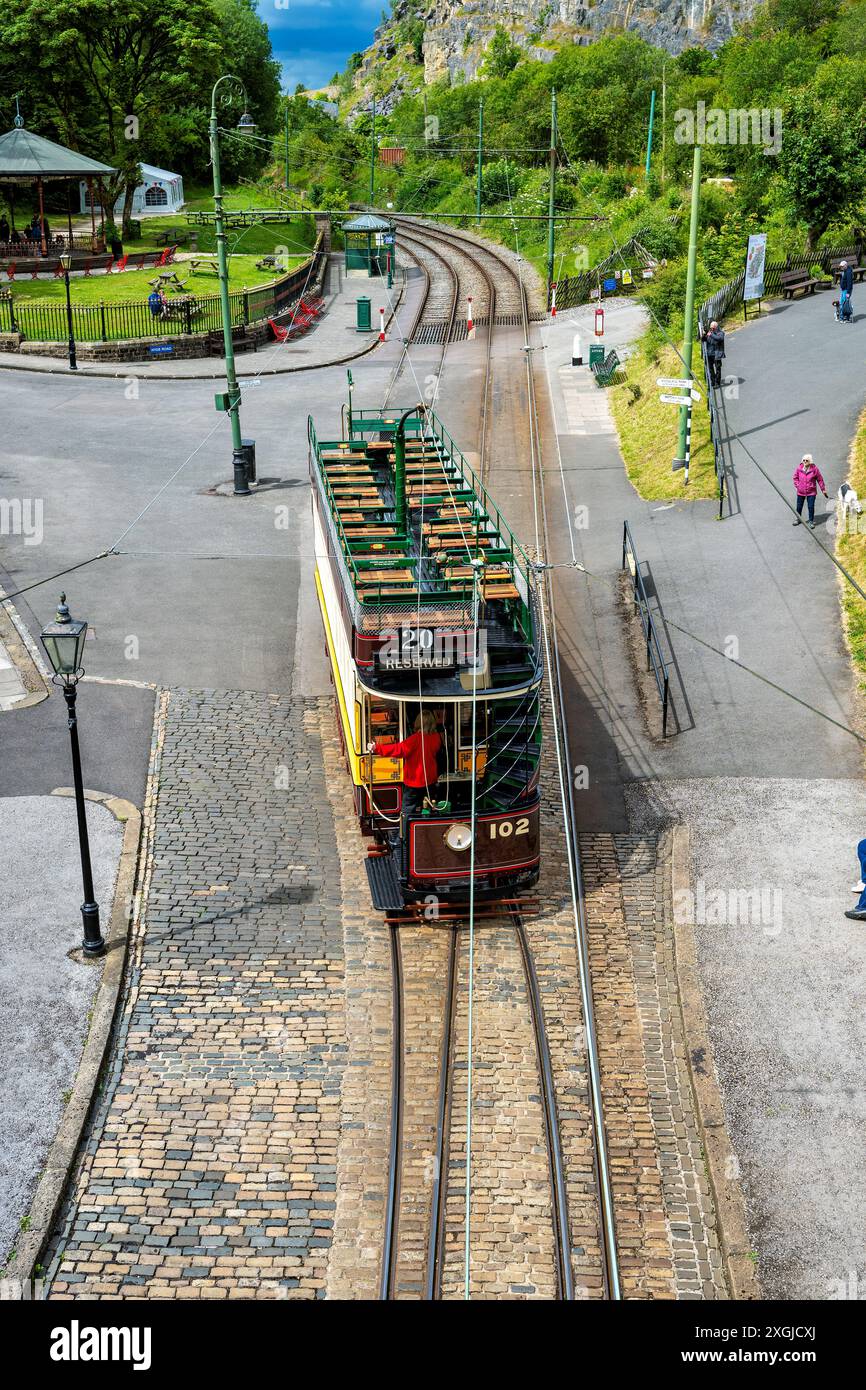 Vintage tram moving along a scenic, tree-lined route in a quaint ...