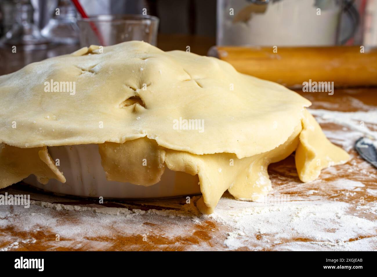 Making a pie: Top crust. Dough is unfolded with edges hanging over the ...