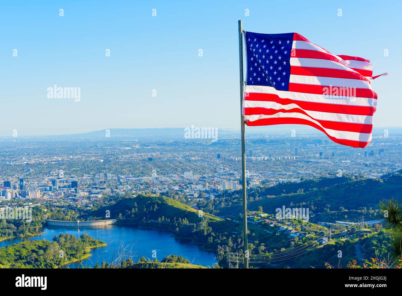 Close-up of a waving American flag with Hollywood Reservoir and Los ...