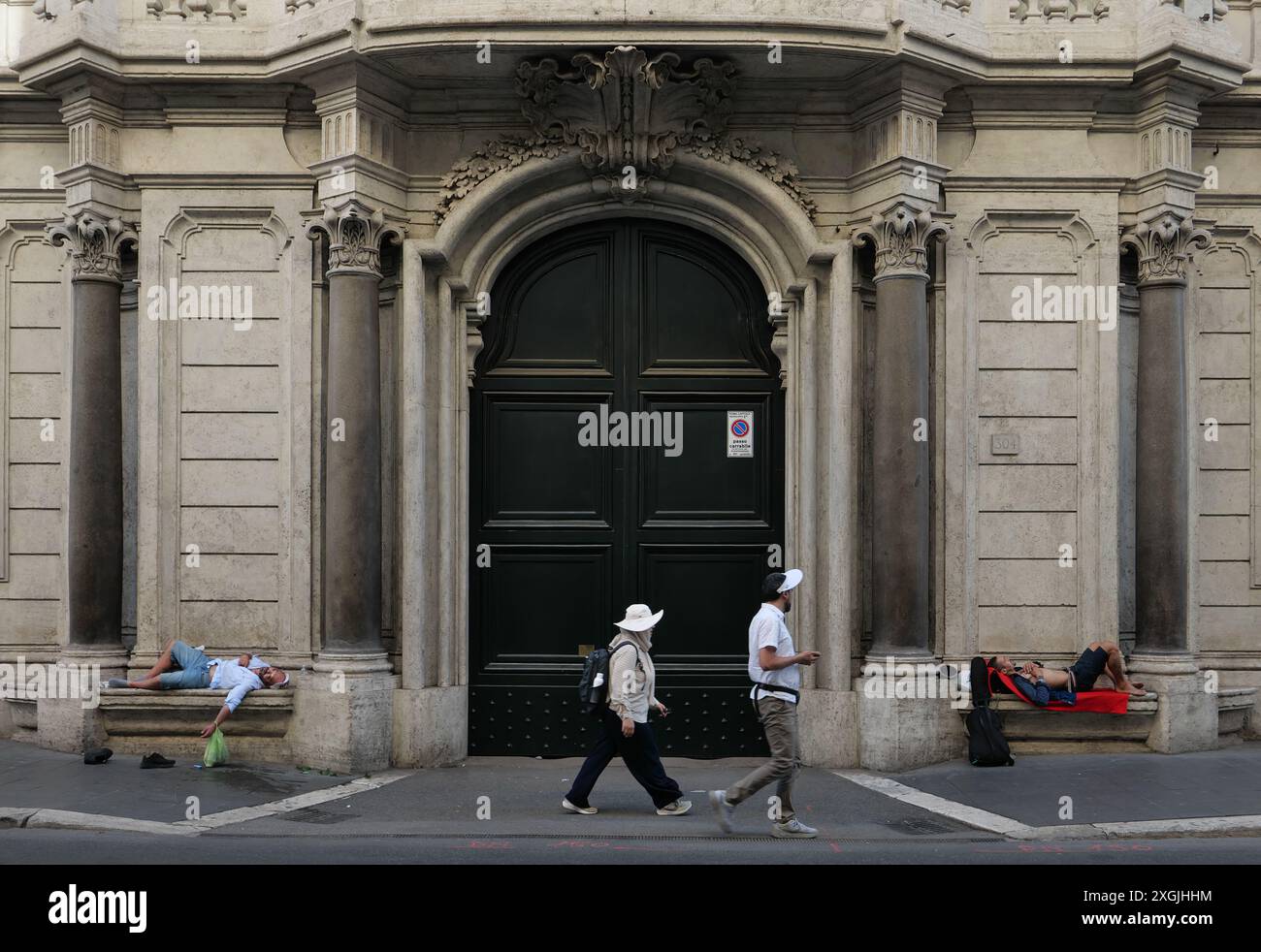 TWO HOMELESS PEOPLE AND TWO TOURISTS IN A STREET IN THE HISTORIC CENTER ...