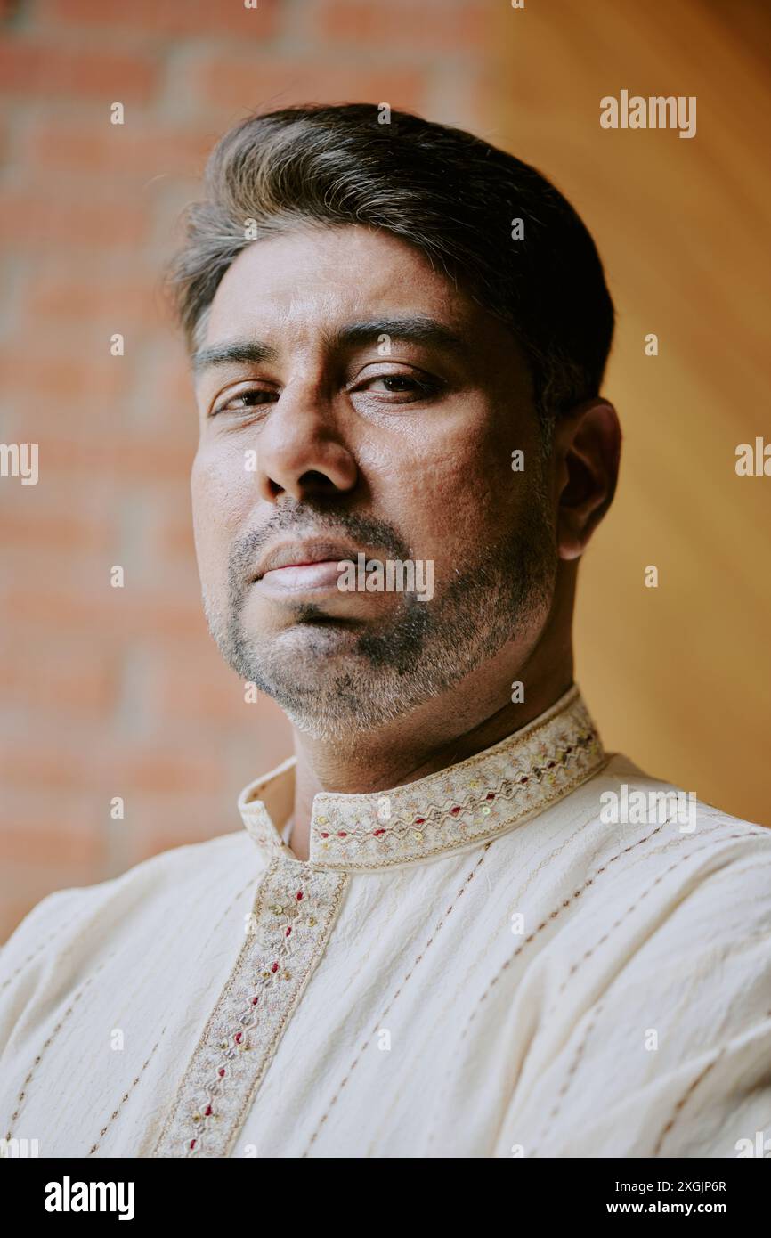 Low angle portrait of Indian man looking at camera with confident ...