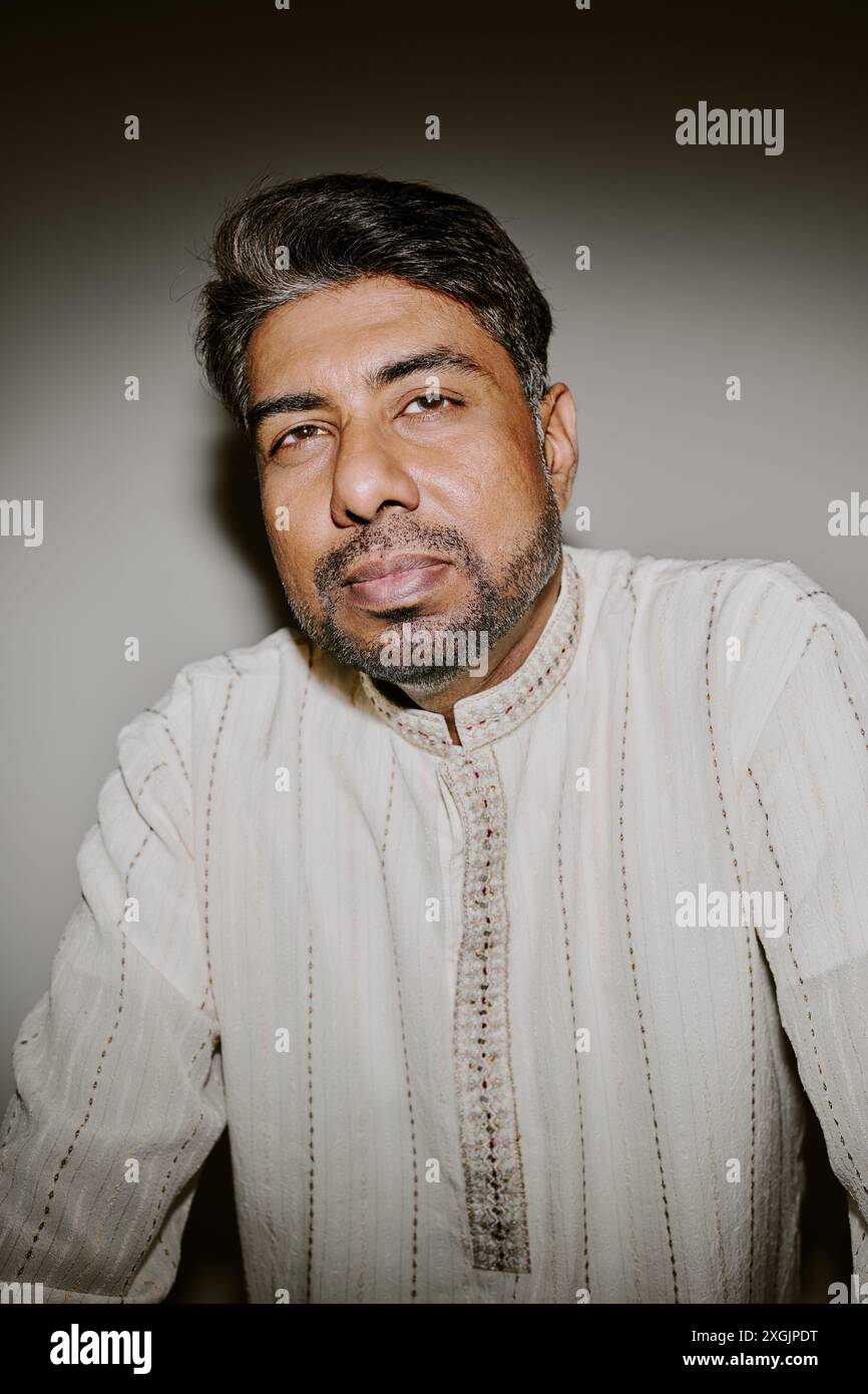 Medium close up of middle aged Indian man dressed in flax robe with red ...