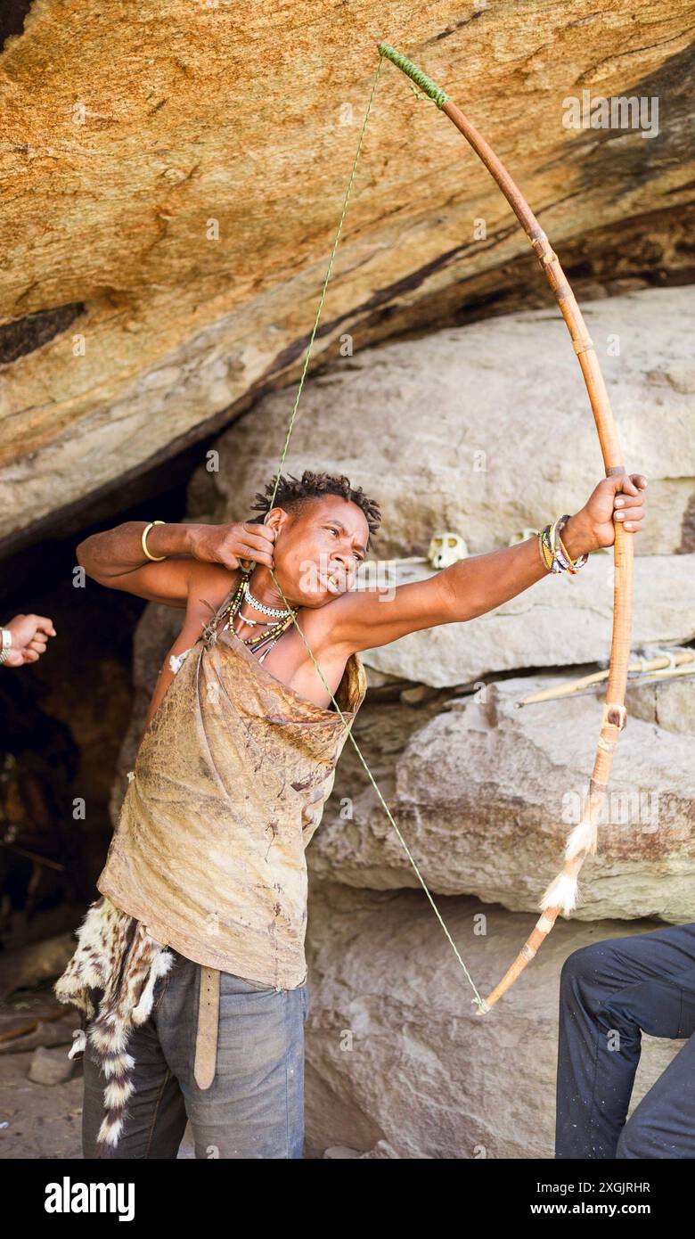 Chief of the Hadzabe tribe demonstrating how to use a bow and arrow ...