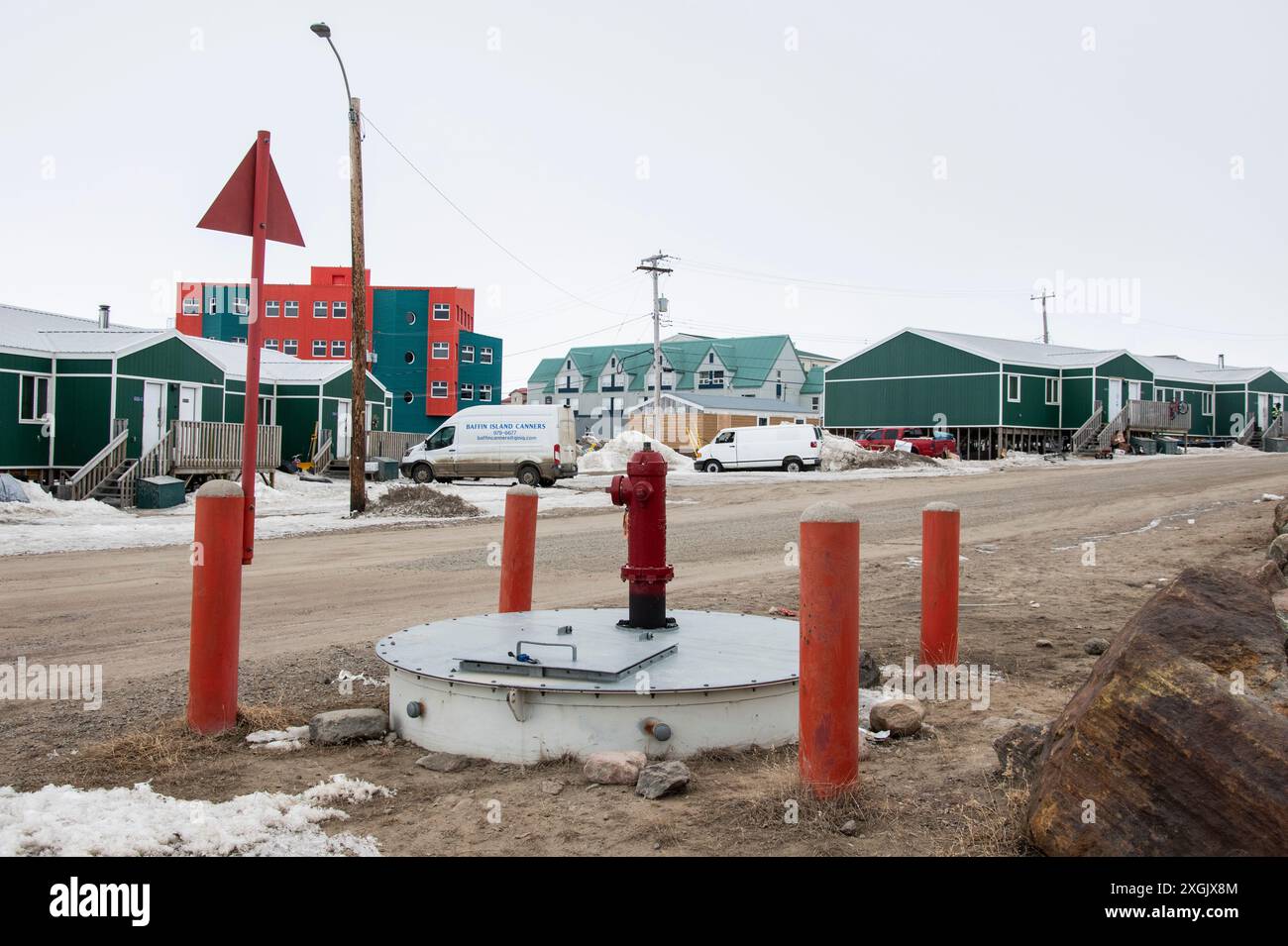 Red fire hydrant protected by bollards in Iqaluit, Nunavut, Canada ...
