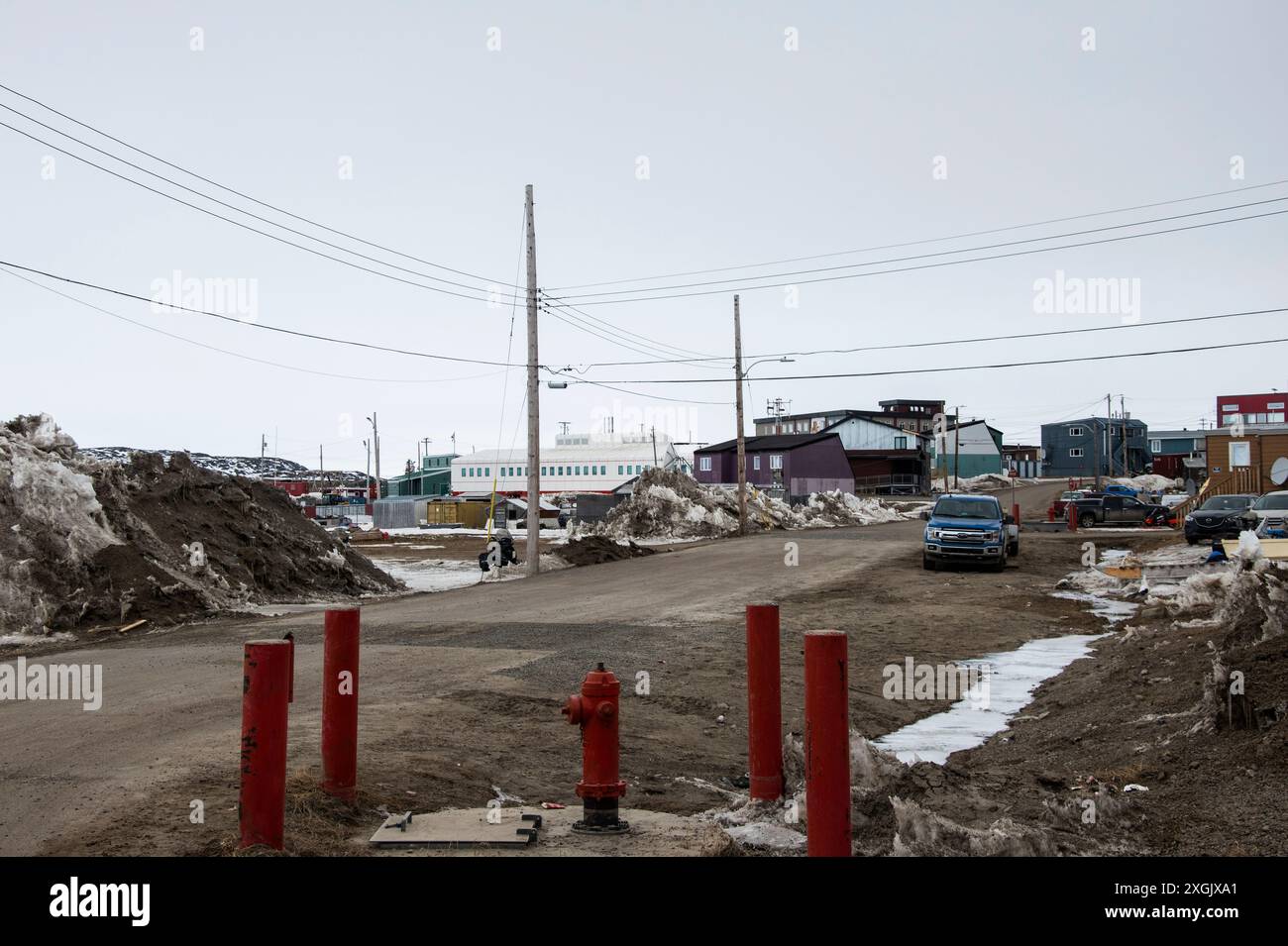 Red fire hydrant protected by bollards in Iqaluit, Nunavut, Canada ...