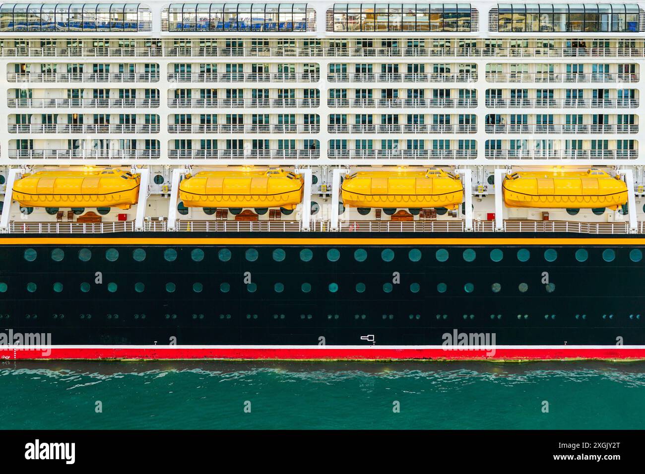 Side view of four yellow lifeboats and balconies on a large cruise ship ...