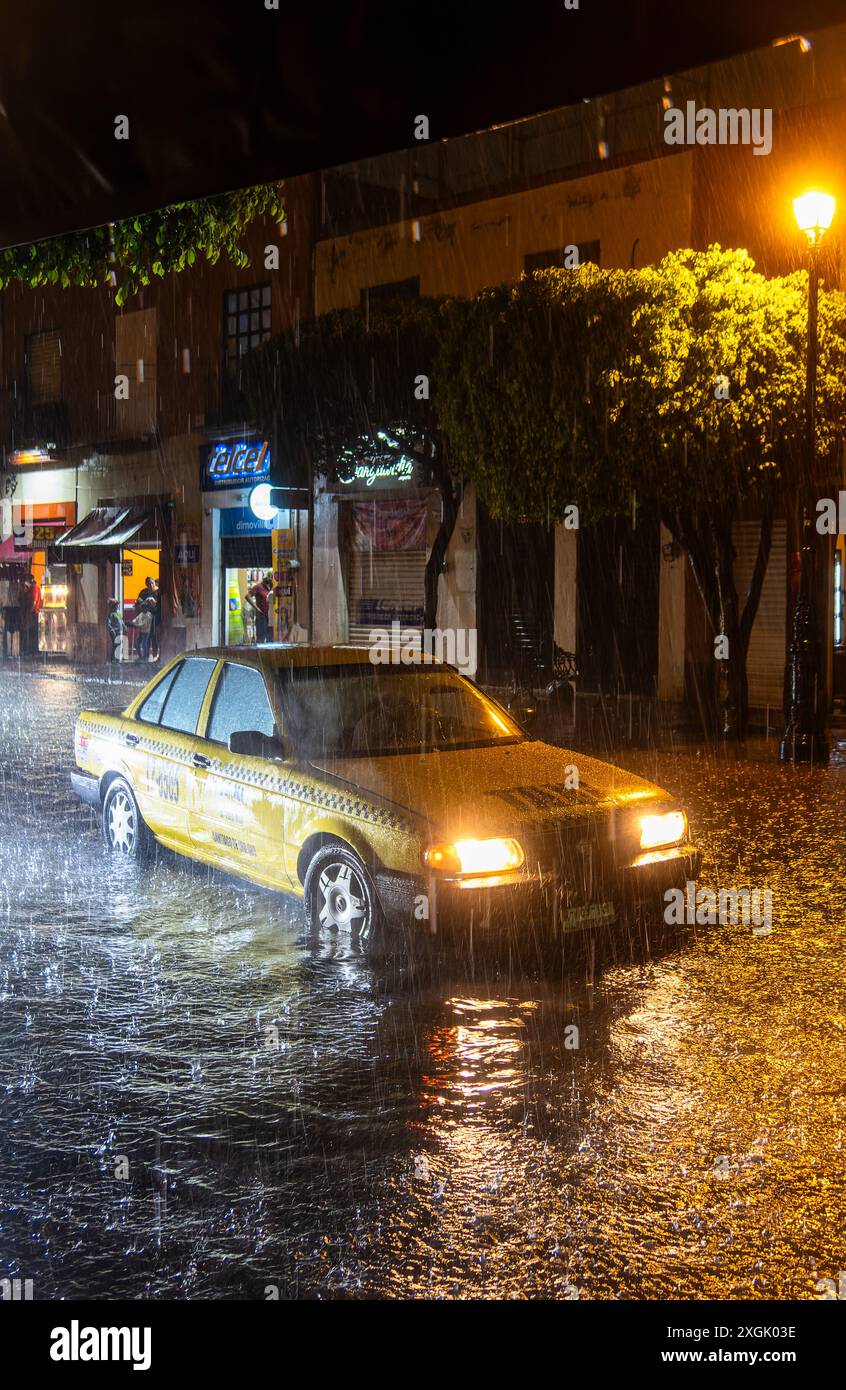 Vibrant urban scene capturing a yellow taxi driving through heavy rain ...
