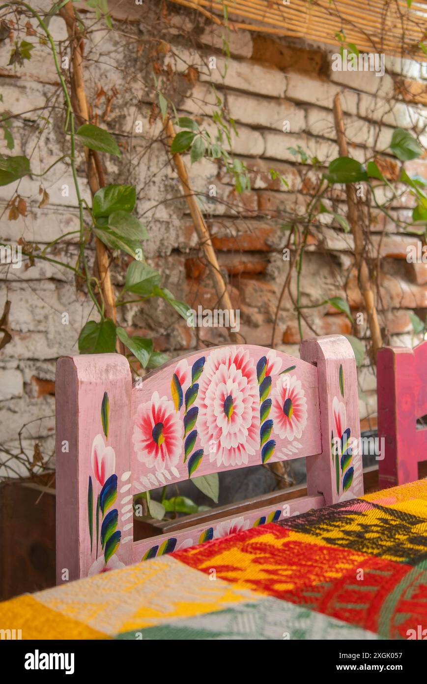 Vibrant hand-painted wooden chair featuring floral designs in a rustic ...