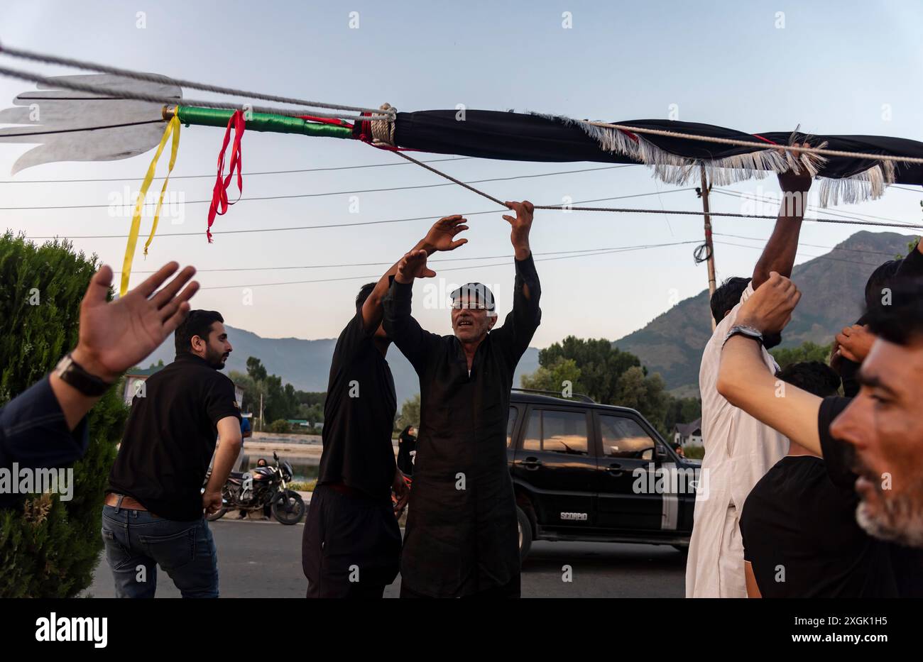 Kashmiri Shia Muslims install a tall religious flag on a road during ...