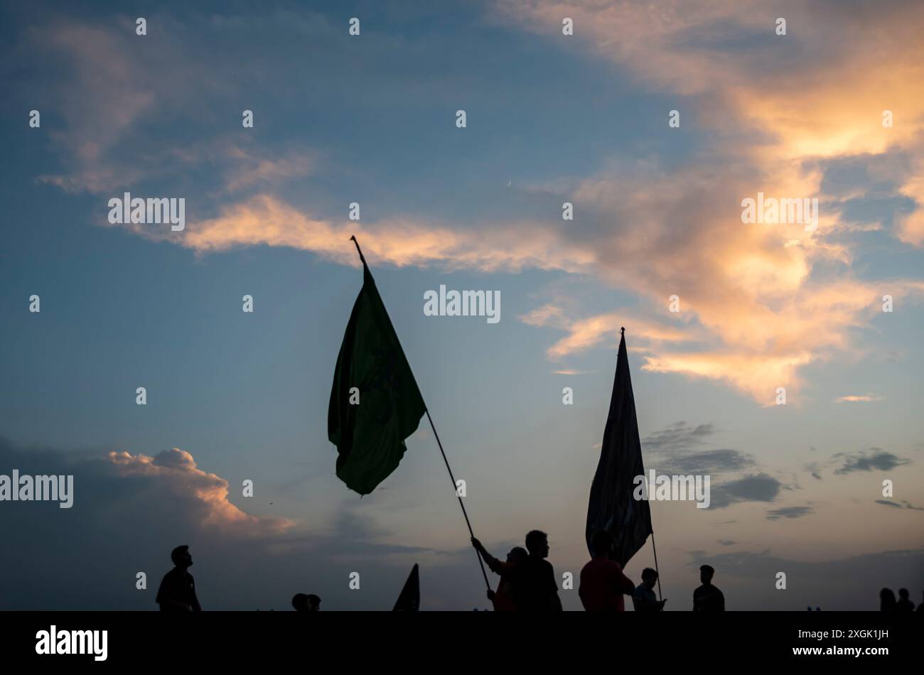 Silhouette of Kashmiri Shia Muslims holding religious flags on a road ...