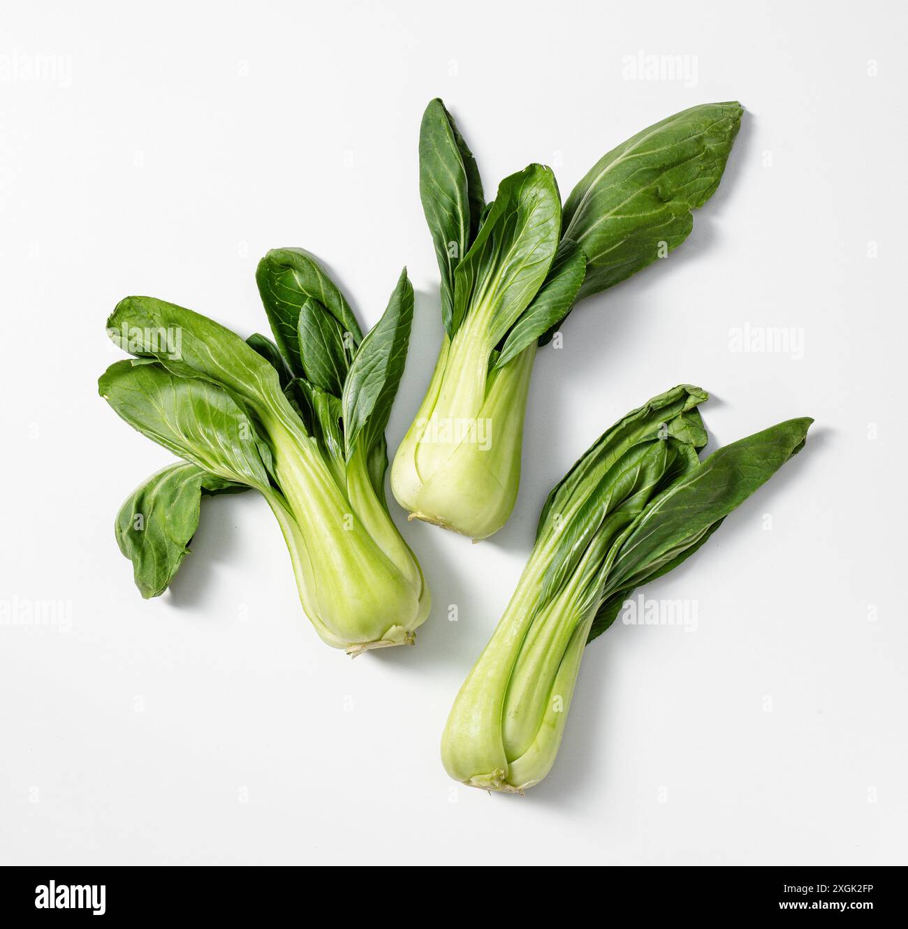 "Top view of three fresh bok choy heads with green leaves, set against ...